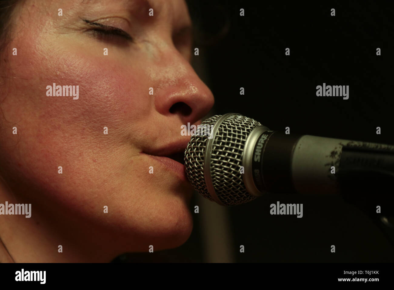 Woman singer sing in in the rehearsal room. Low Key Stock Photo - Alamy