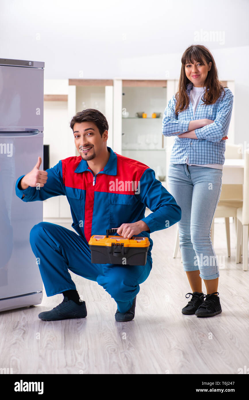 Man repairing fridge with customer Stock Photo - Alamy