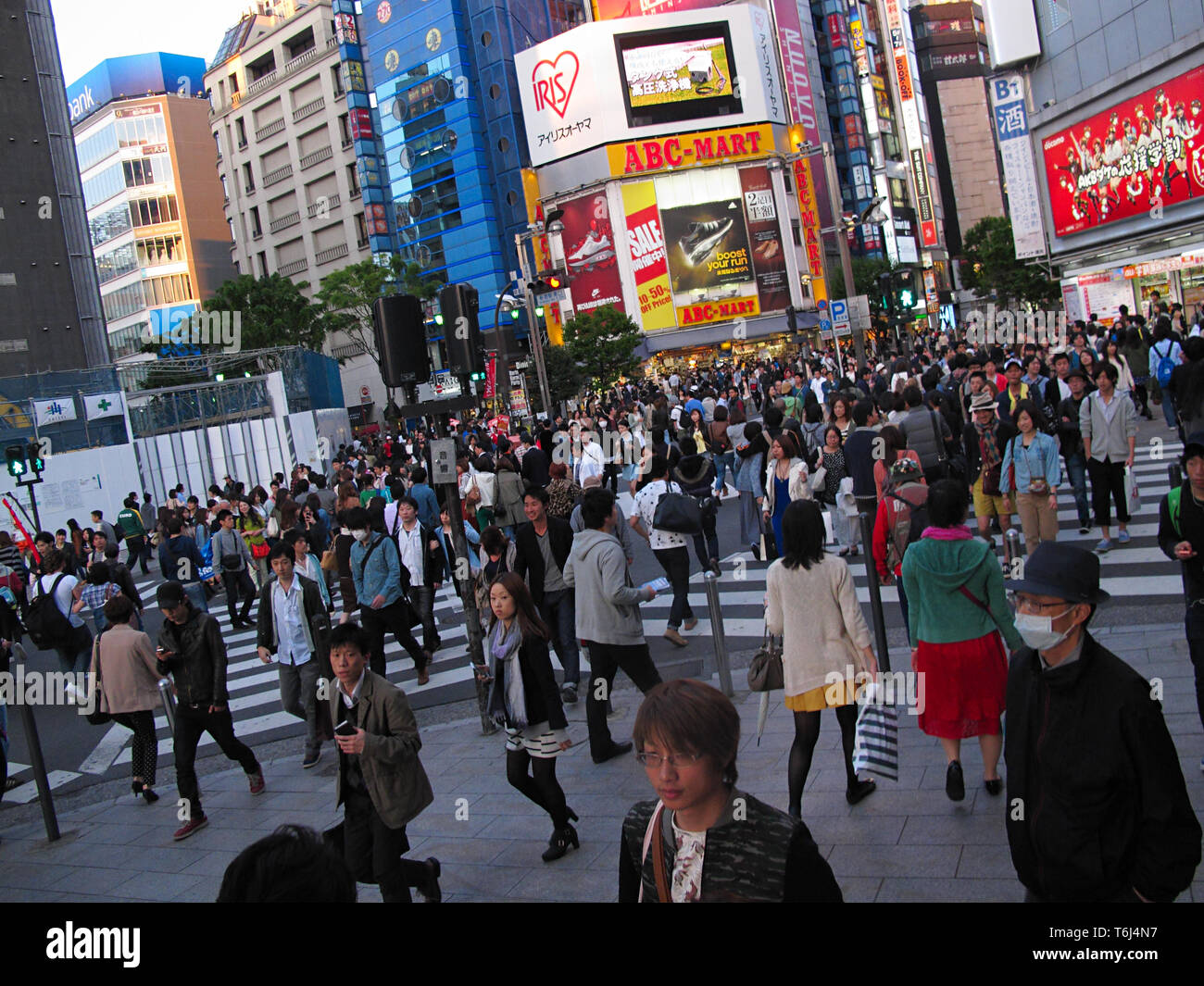 People walk across the streets in the very busy Shinjuku district in ...