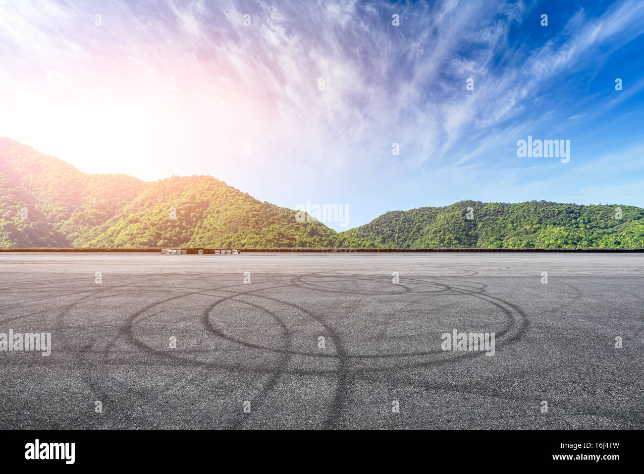 Empty asphalt race track and beautiful natural landscape at sunset ...
