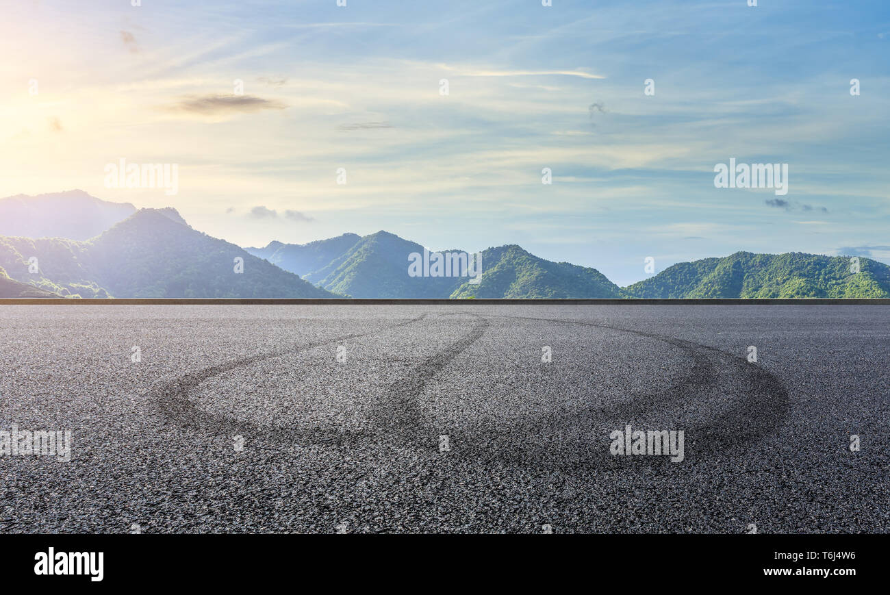Empty asphalt race track and beautiful natural landscape at sunset ...