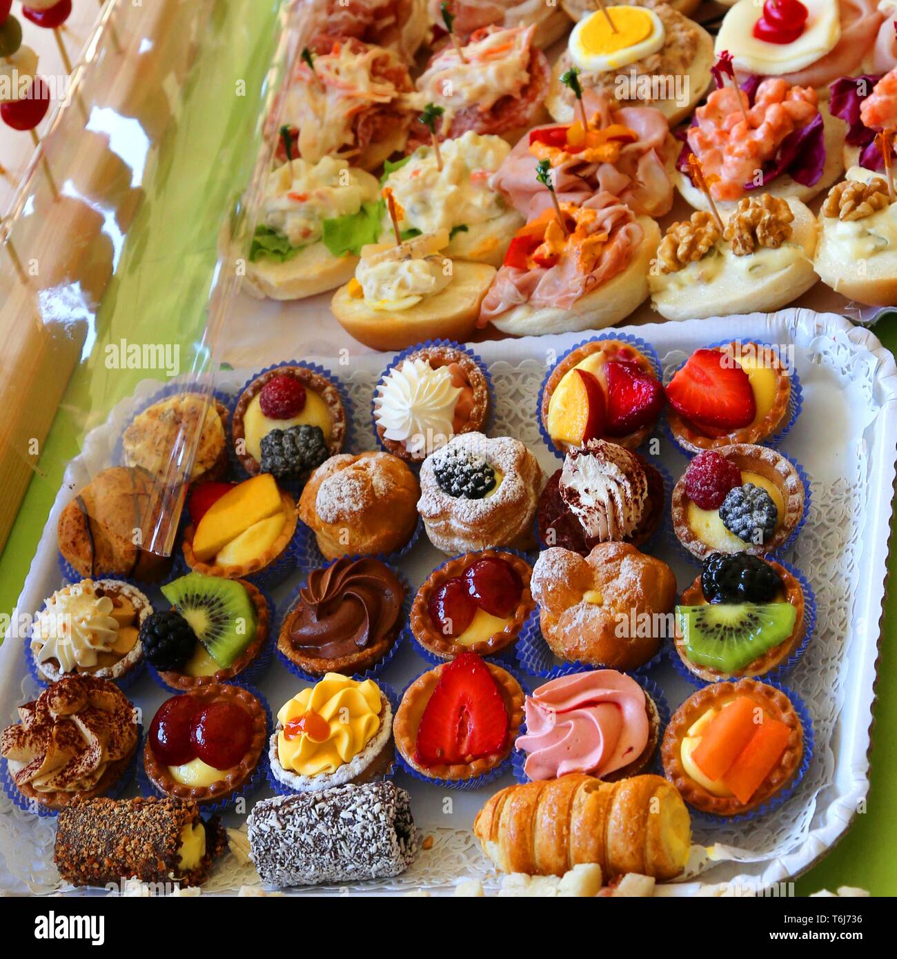 buffet with trays filled with sweet pastries and sandwiches Stock Photo ...