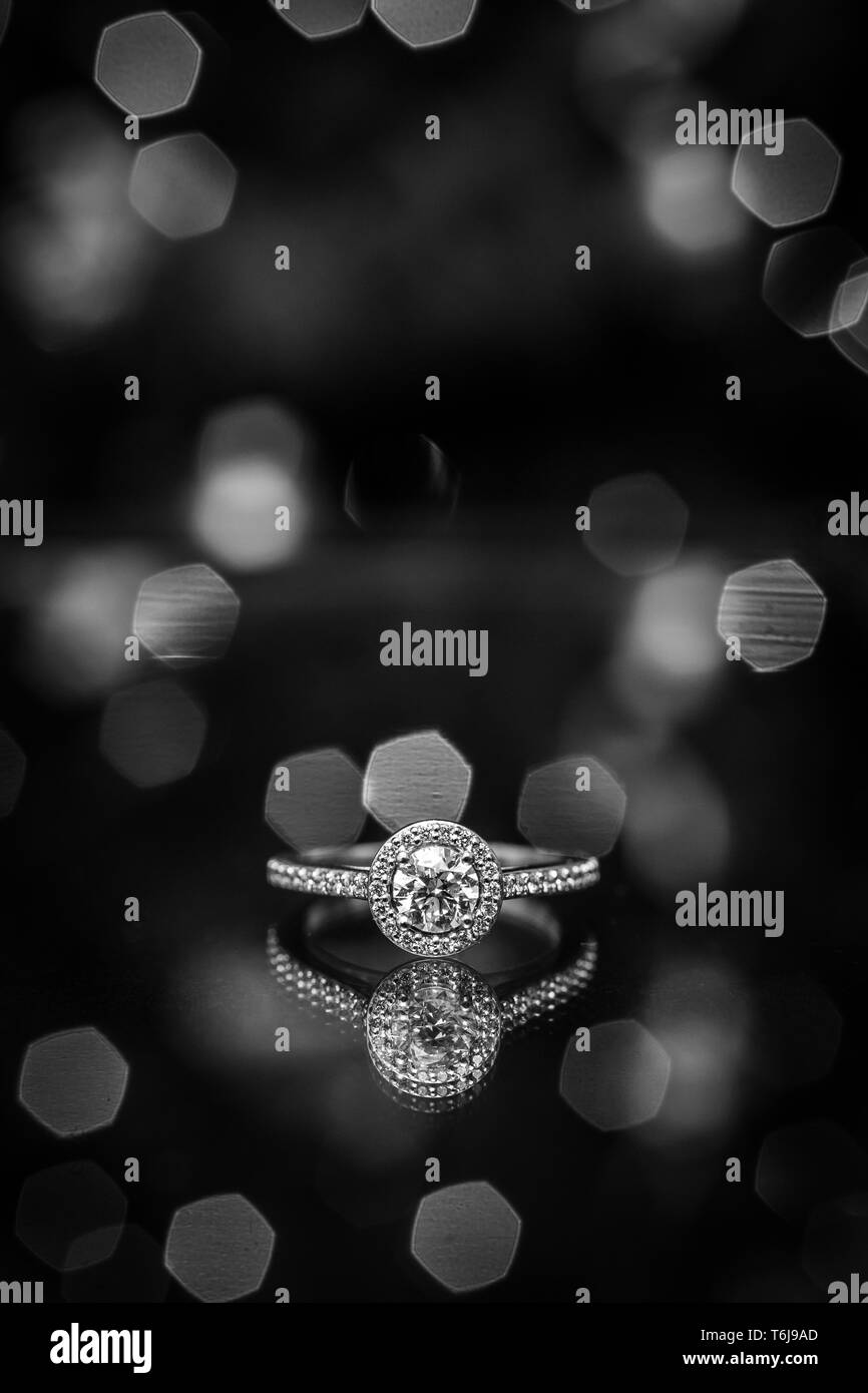 Engagement ring with lights in the background and a reflection below ...