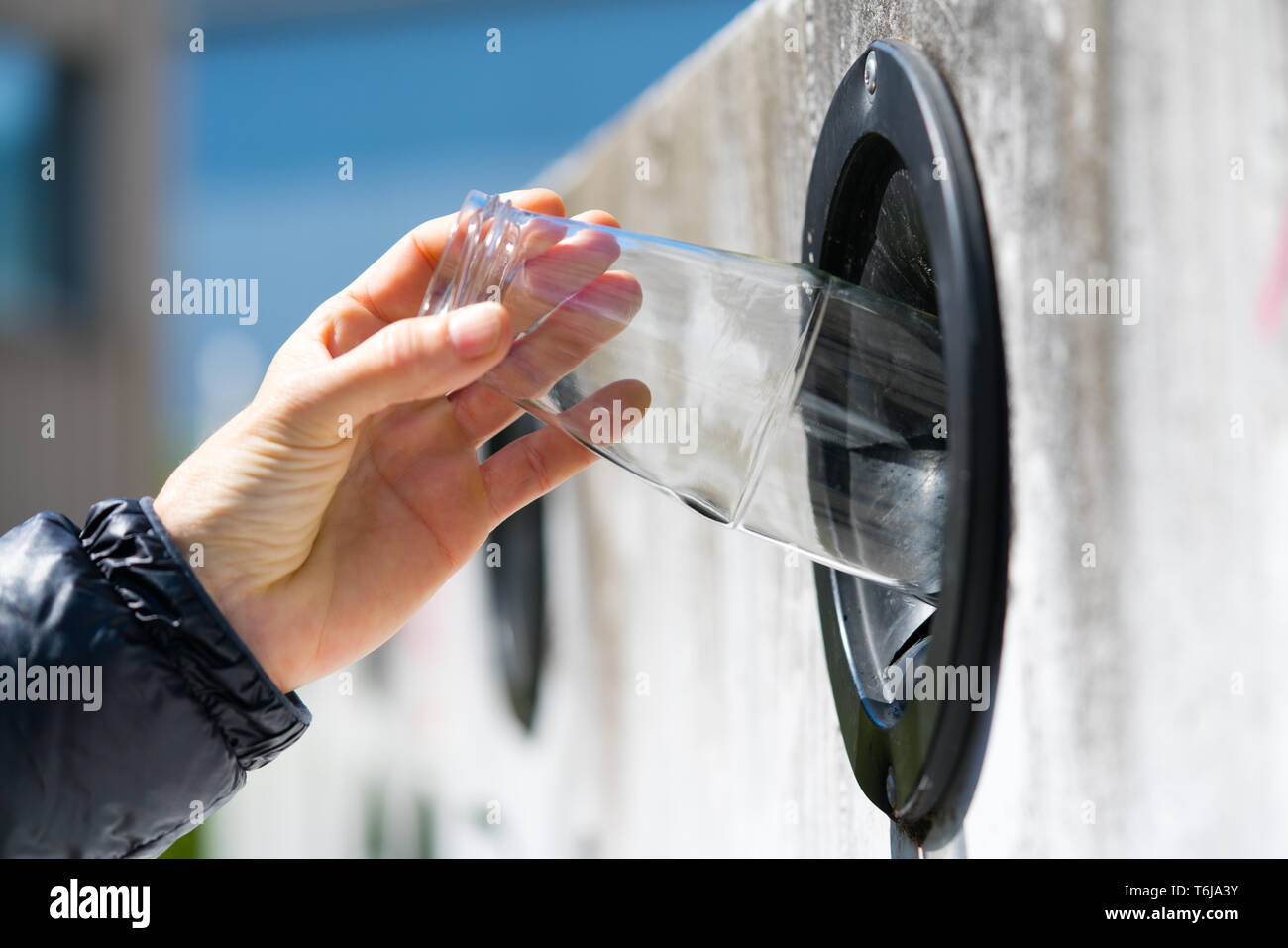 detail view of a female hand recycling glass to save the environment at ...