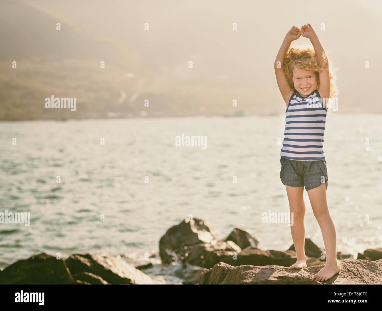 Little girl with raised hands Stock Photo - Alamy