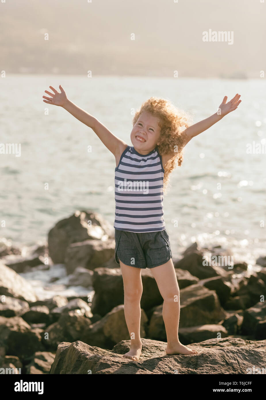 Little girl with raised hands Stock Photo - Alamy