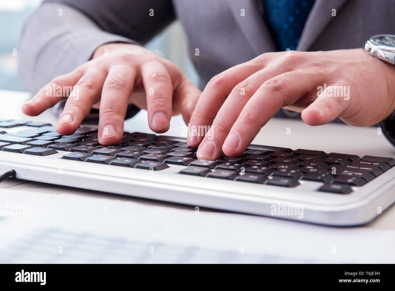 Finance professional working on keyboard with reports Stock Photo - Alamy