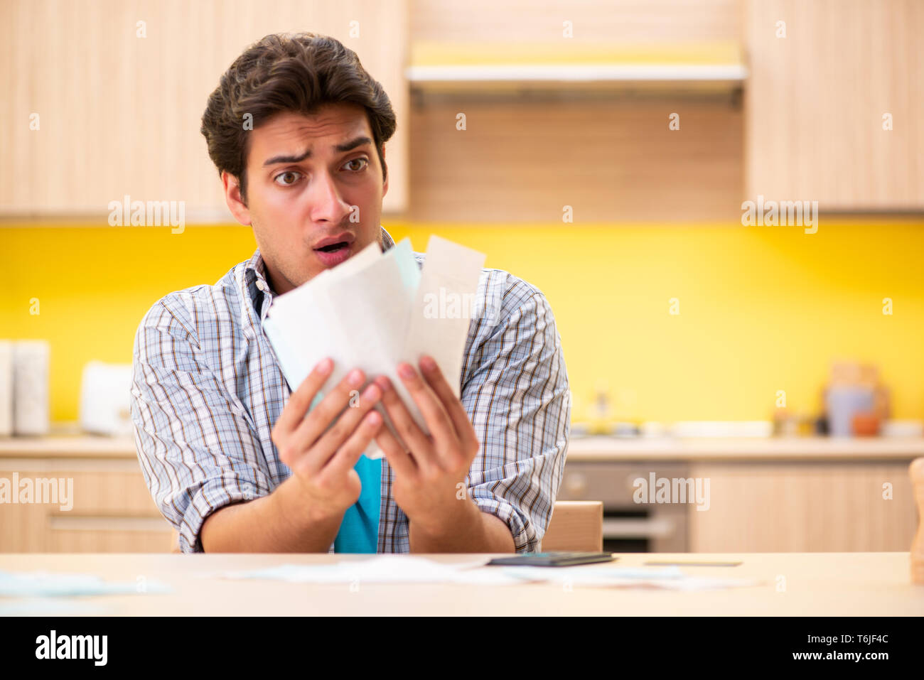 Young man husband in budget planning concept Stock Photo - Alamy