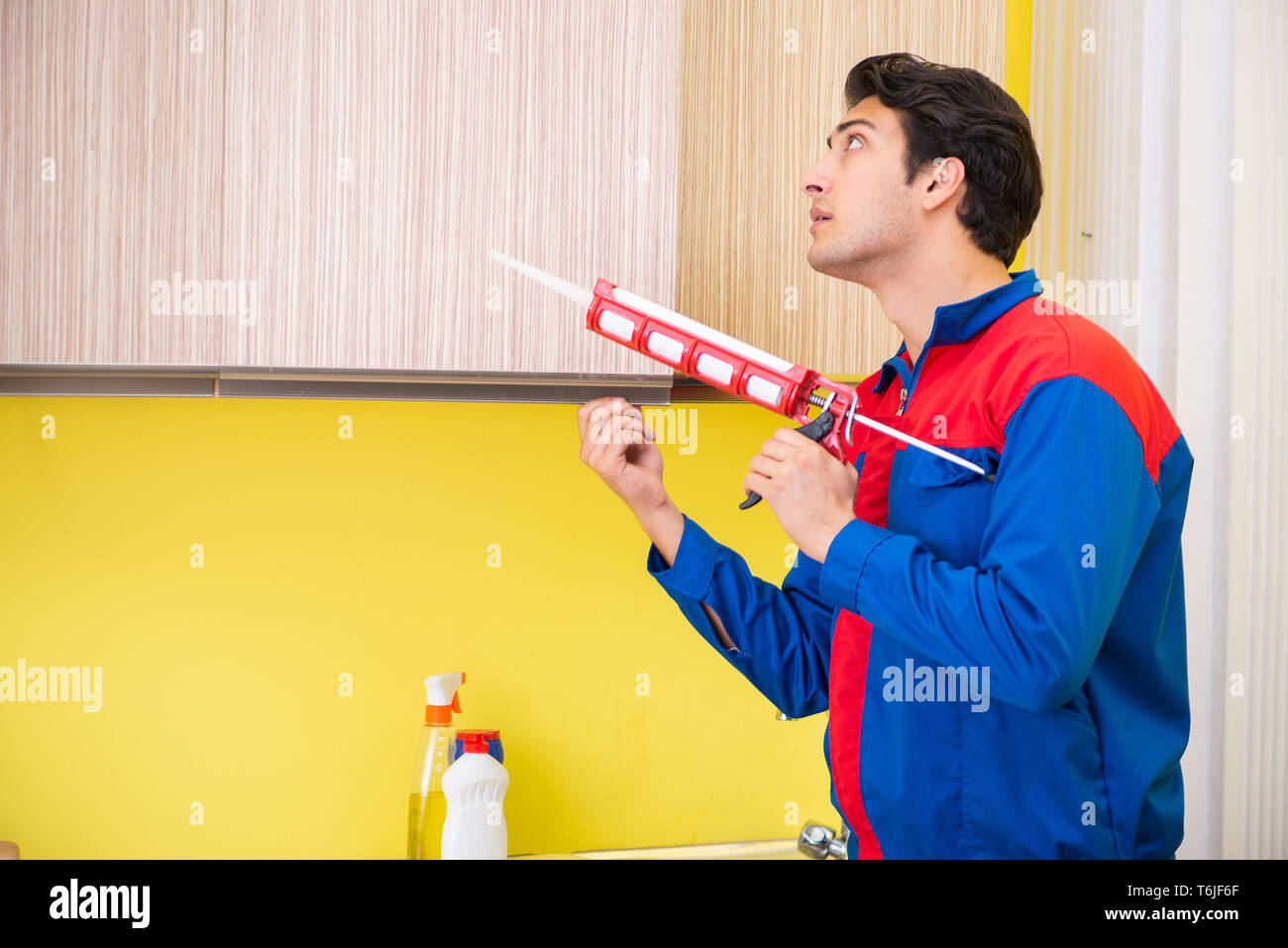 Repairman working in the kitchen Stock Photo - Alamy
