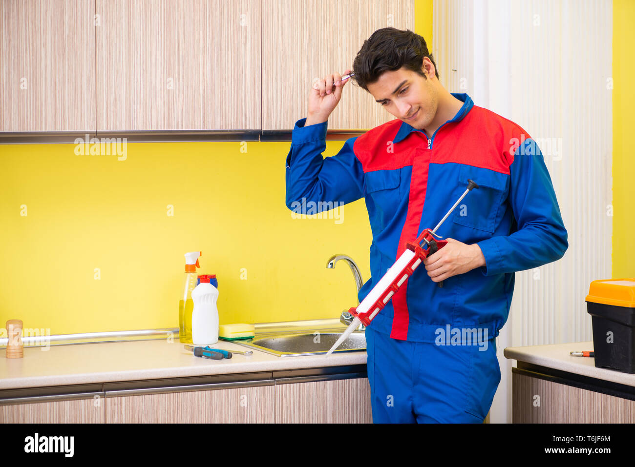 Repairman working in the kitchen Stock Photo - Alamy