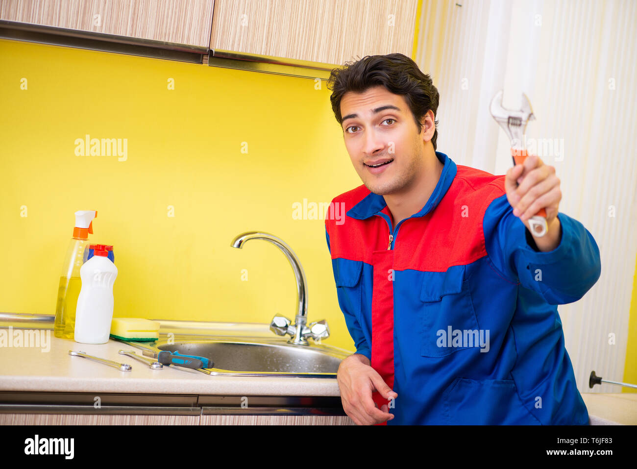 Plumber repairing tap at kitchen Stock Photo - Alamy