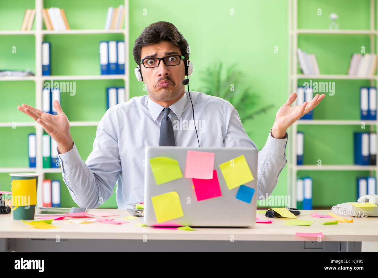 Young help desk operator working in office with many conflicting Stock ...