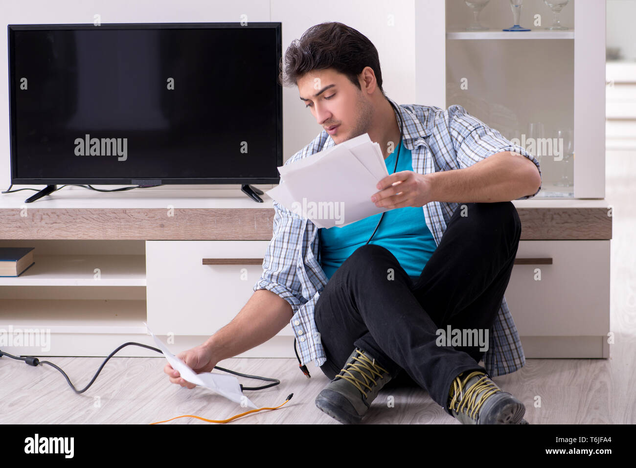 Man trying to fix broken tv Stock Photo - Alamy