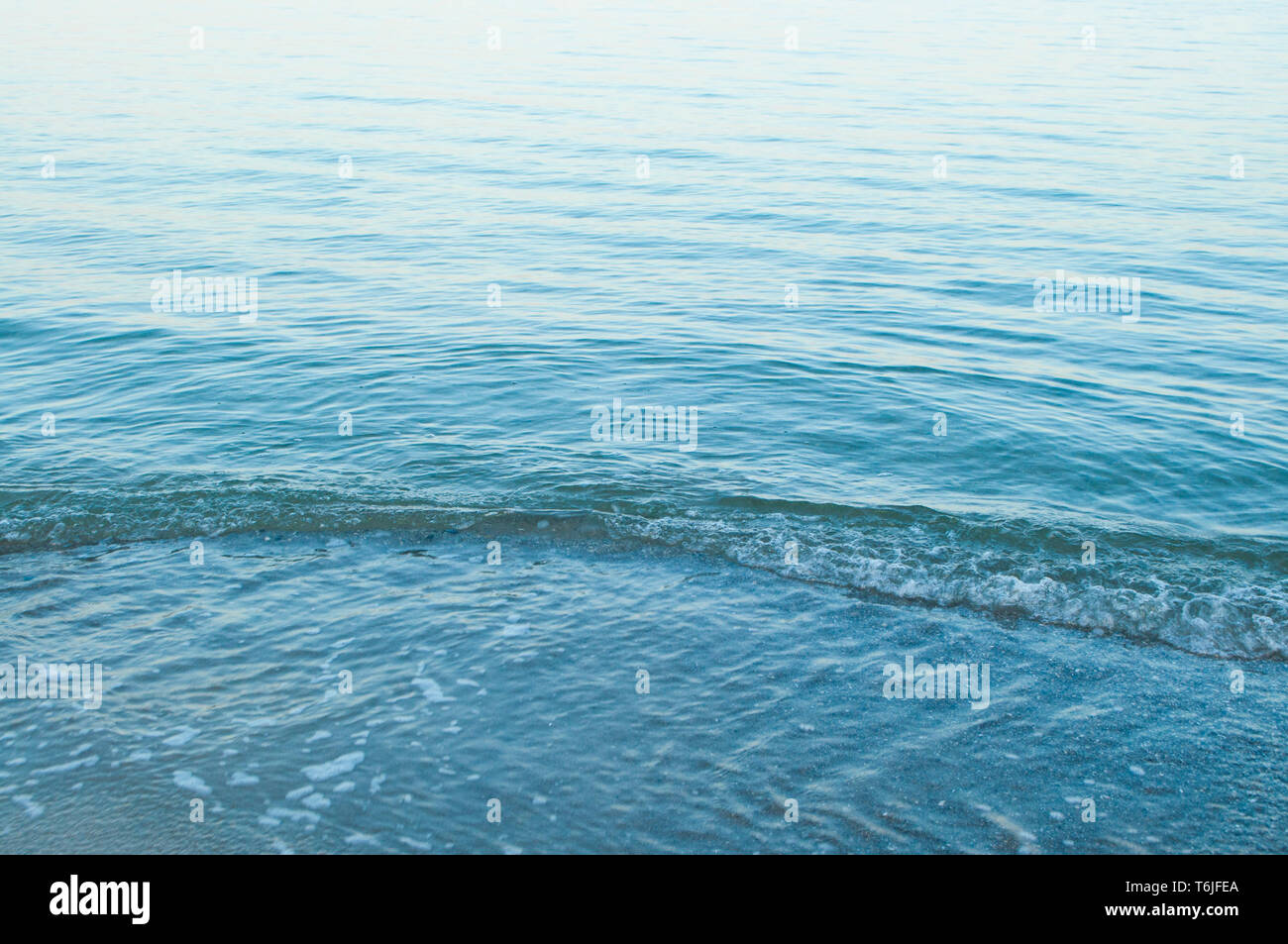 Surface of sea water colored by sunset light Stock Photo - Alamy