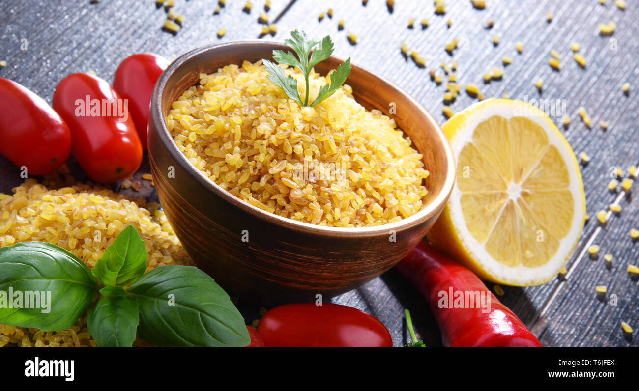 Bowl of uncooked bulgur on wooden table Stock Photo - Alamy