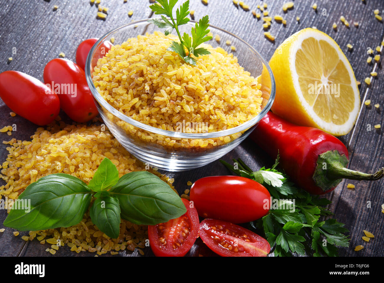 Bowl of uncooked bulgur on wooden table Stock Photo - Alamy