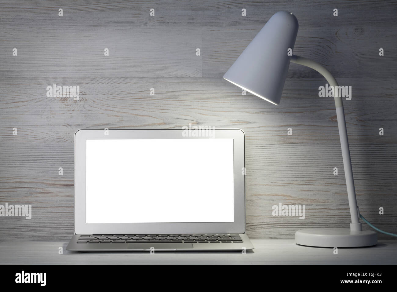 Home office workplace with blank white screen laptop computer. With ...