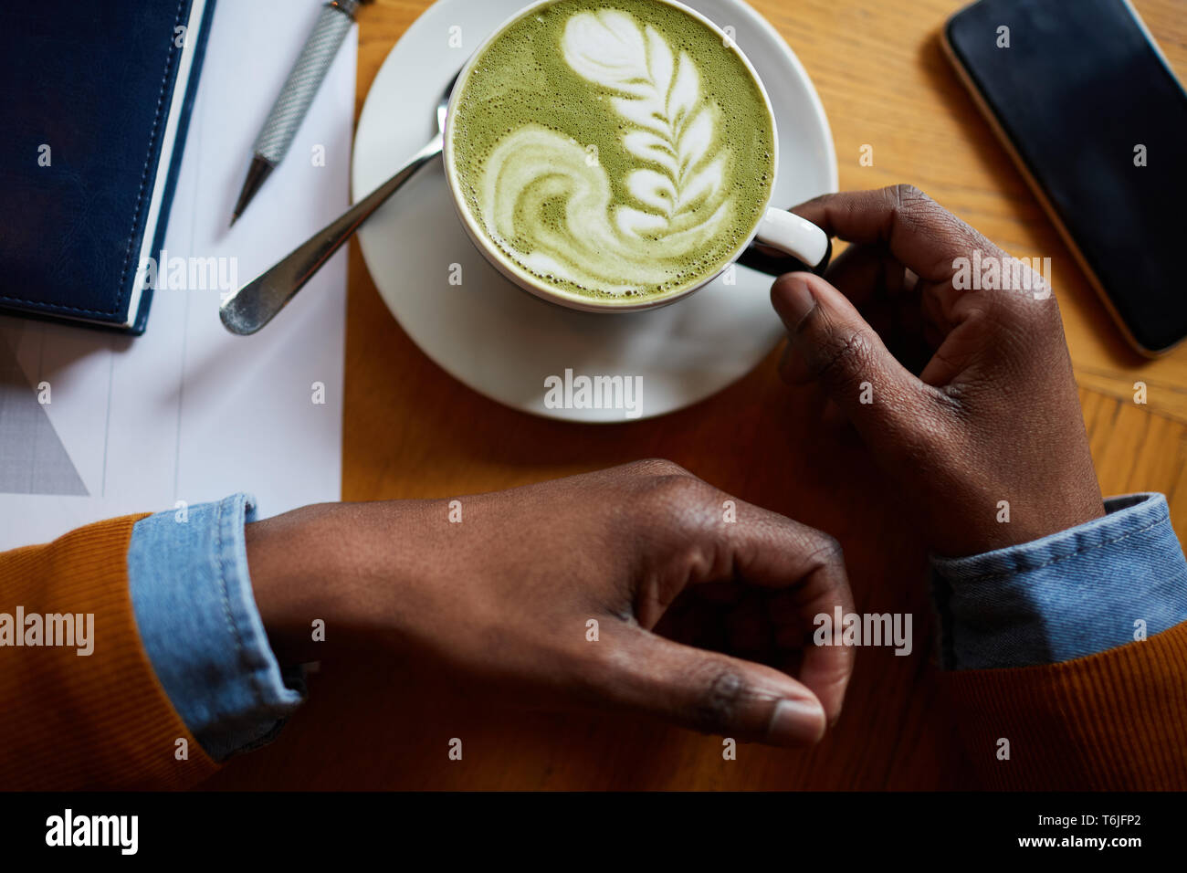 Top view close up of unrecognizable African-American man drinking latte ...