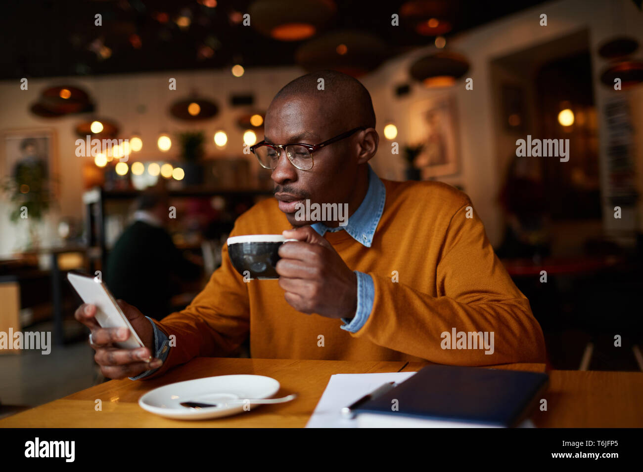 Warm toned portrait of contemporary African-American man using ...