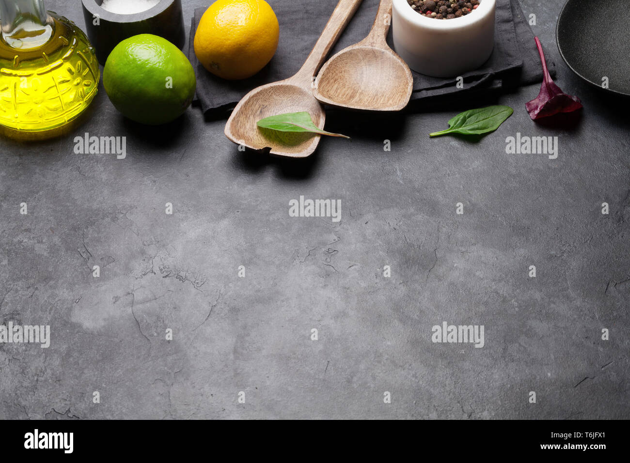 Cooking wooden utensils, empty plate, condiments and spices on stone ...