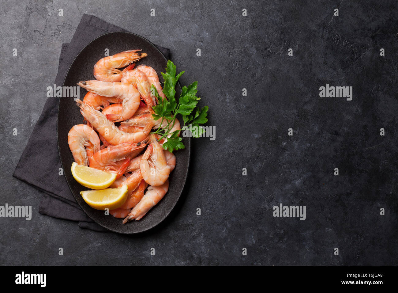 Steamed tiger shrimps with parsley and lemon. Top view with copy space ...