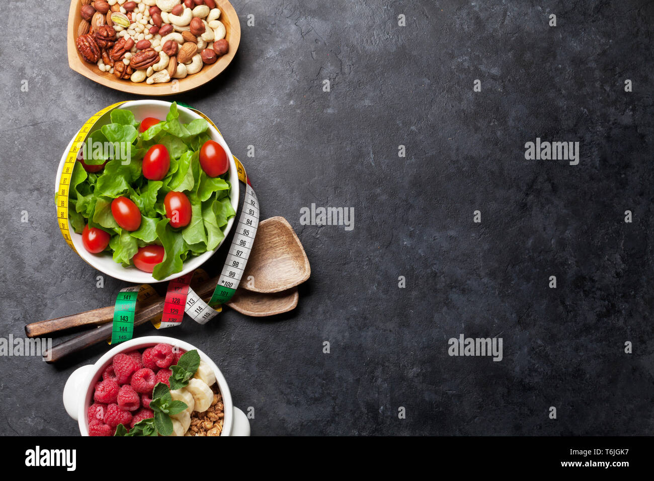 Healthy food and fitness concept. Salad, fruits, vegetables, nuts and ...