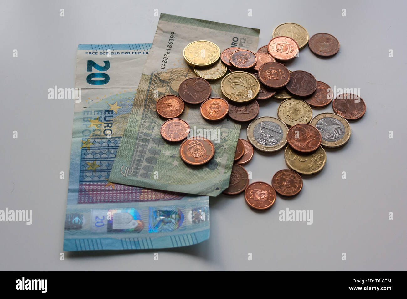 Dirty money euro banknotes and coins on white table. Dark business ...