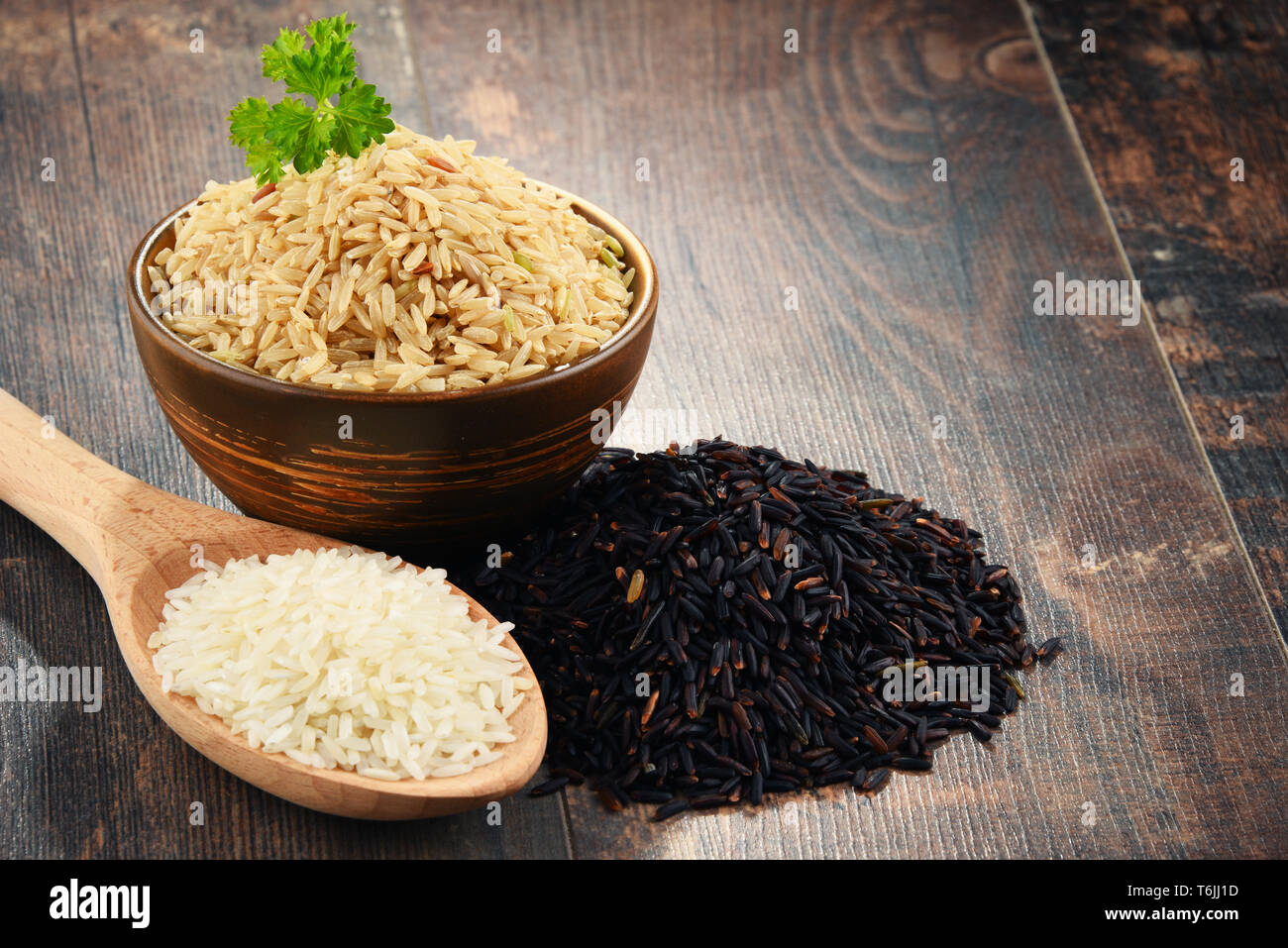 Composition with bowl of rice on wooden table Stock Photo - Alamy