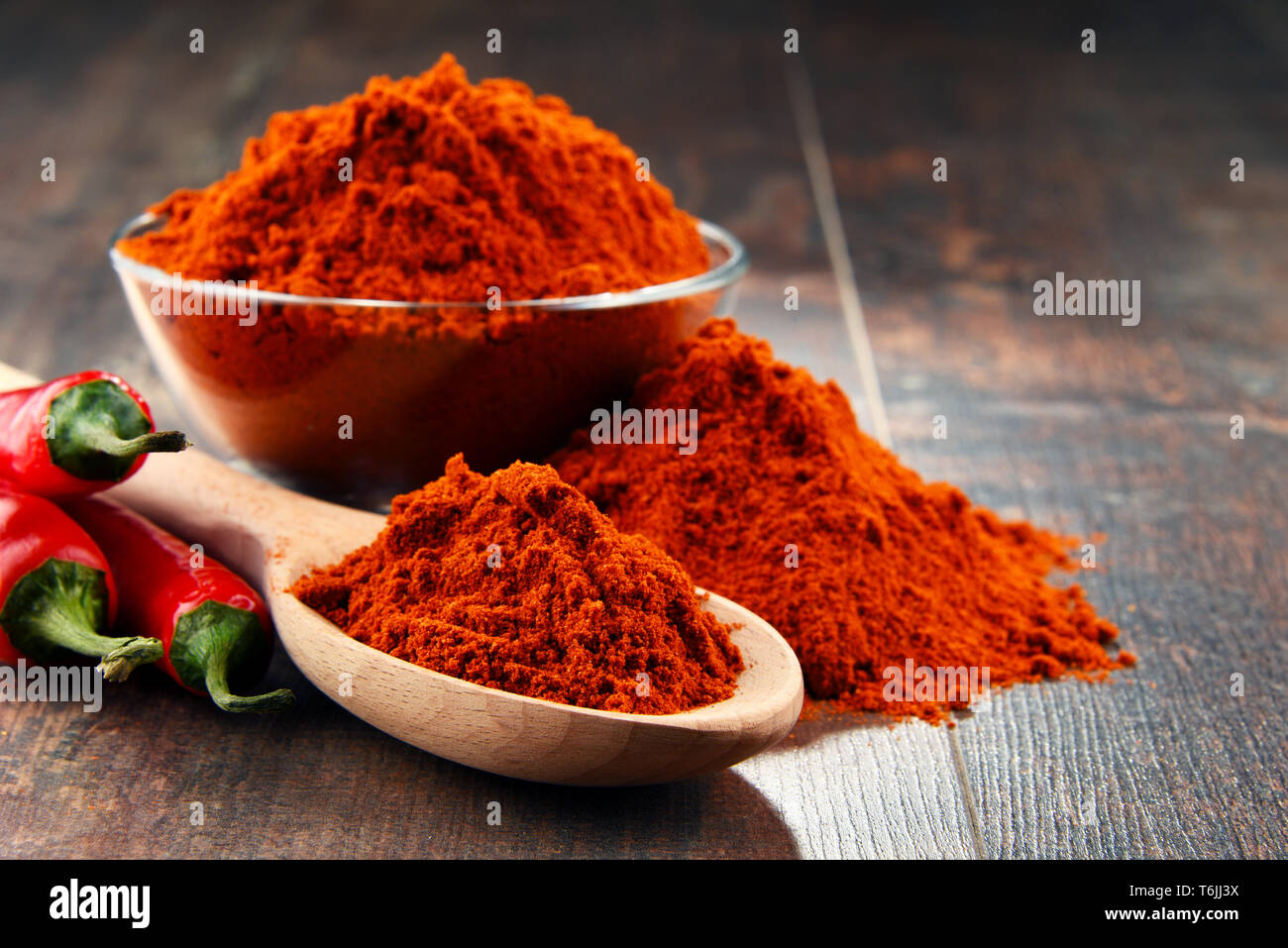 Composition with bowl of chili powder on wooden table Stock Photo - Alamy