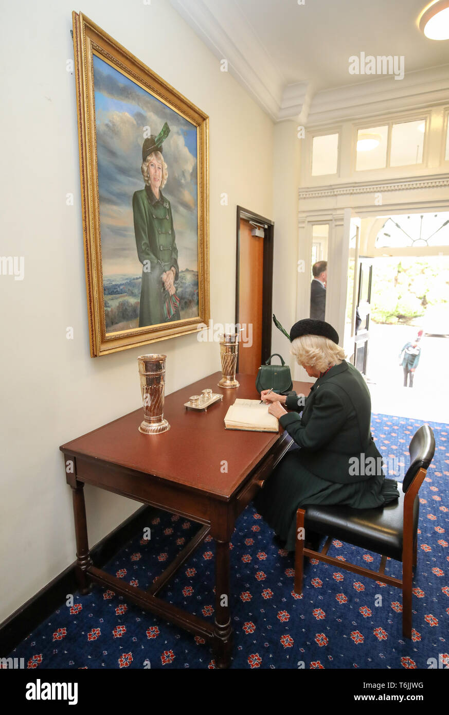 The Duchess of Cornwall signs the visitors book in the Officer's mess ...