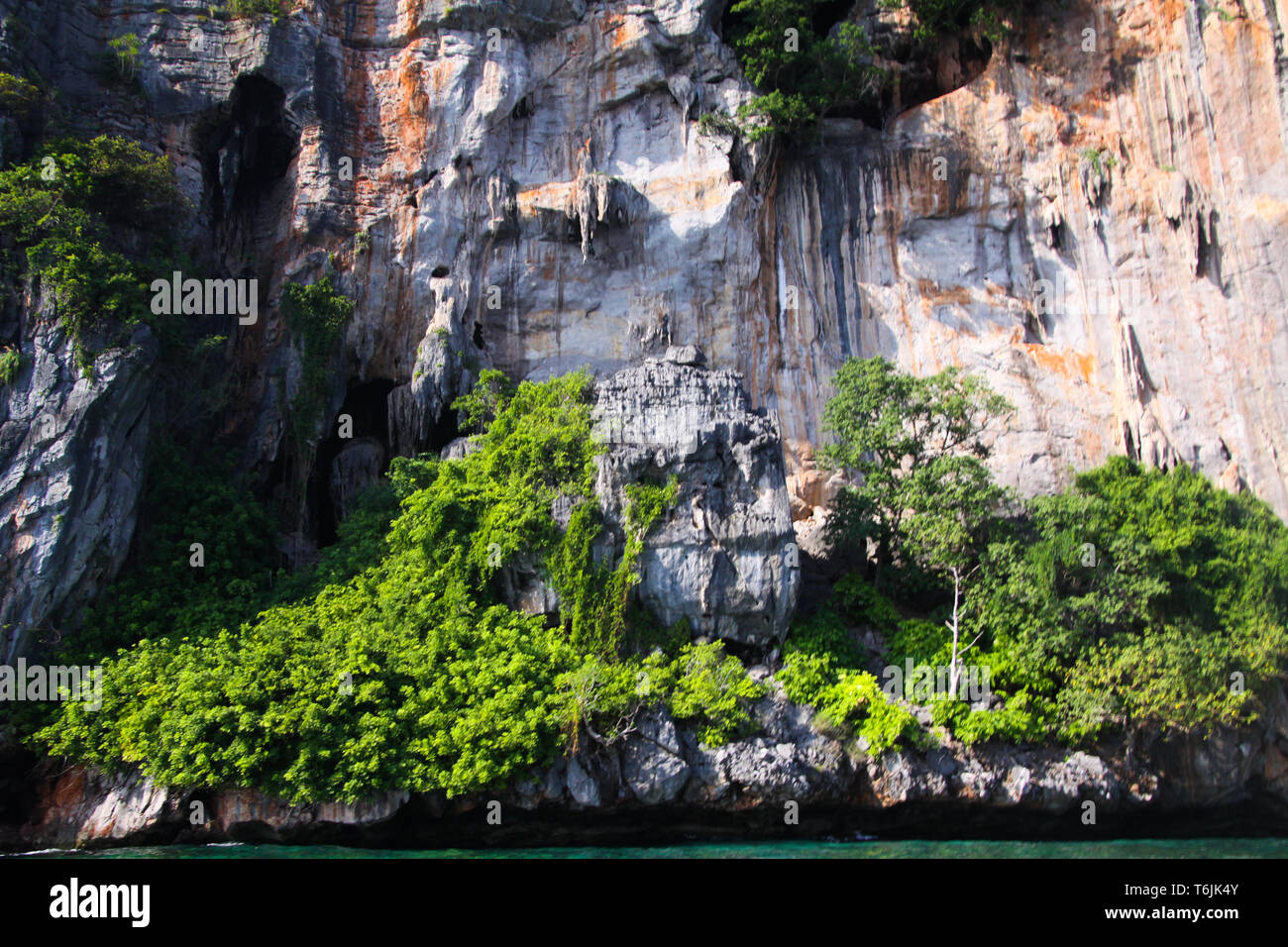 Boat trip around impressive steep rough cliffs of tropical island Ko ...