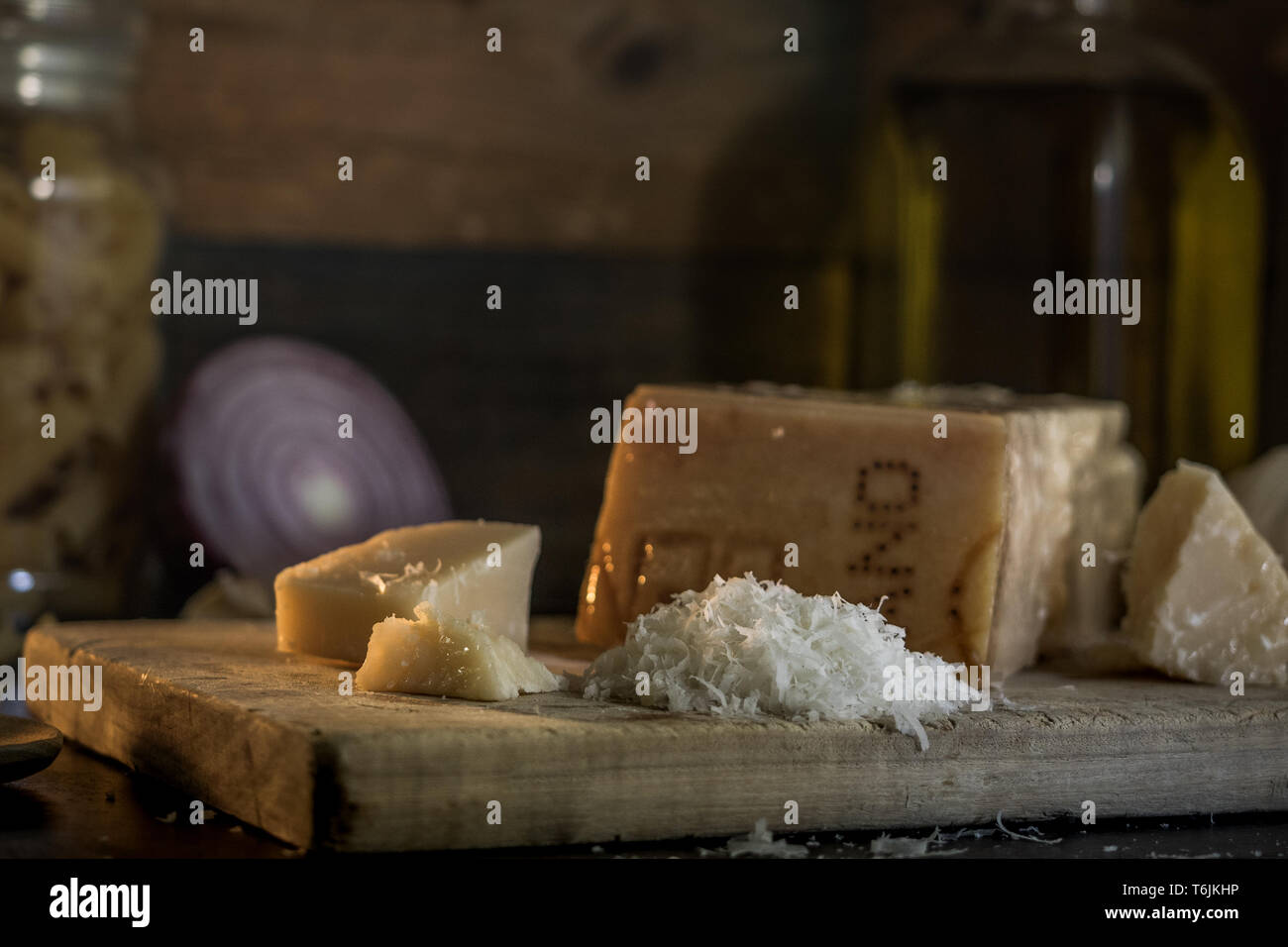 Parmesan cheese piece on wooden board. Grated Parmesan cheese with ...