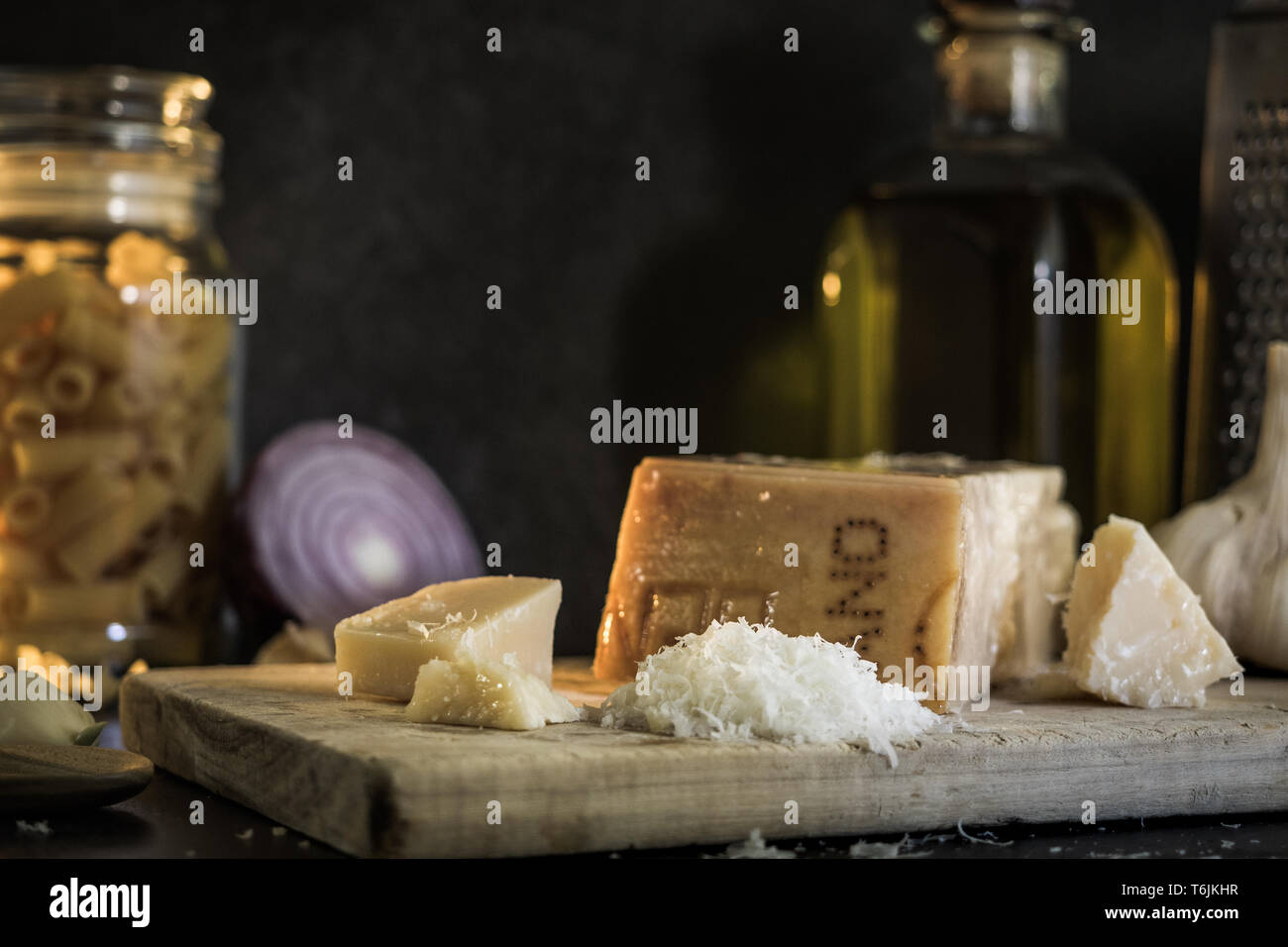 Parmesan cheese piece on wooden board. Grated Parmesan cheese with ...