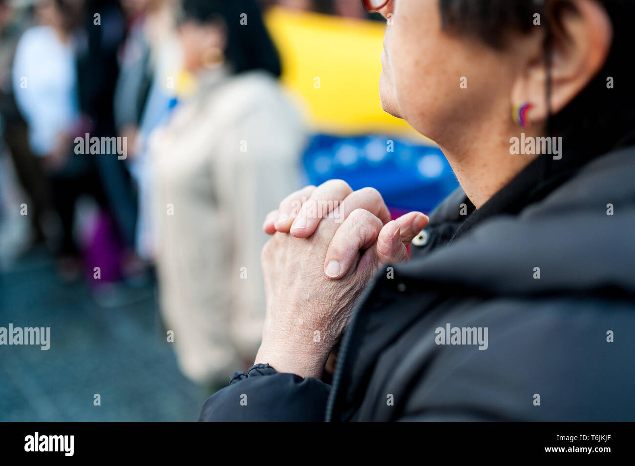 old venezuelan woman praying with venezuelan flag in Barcelona city ...