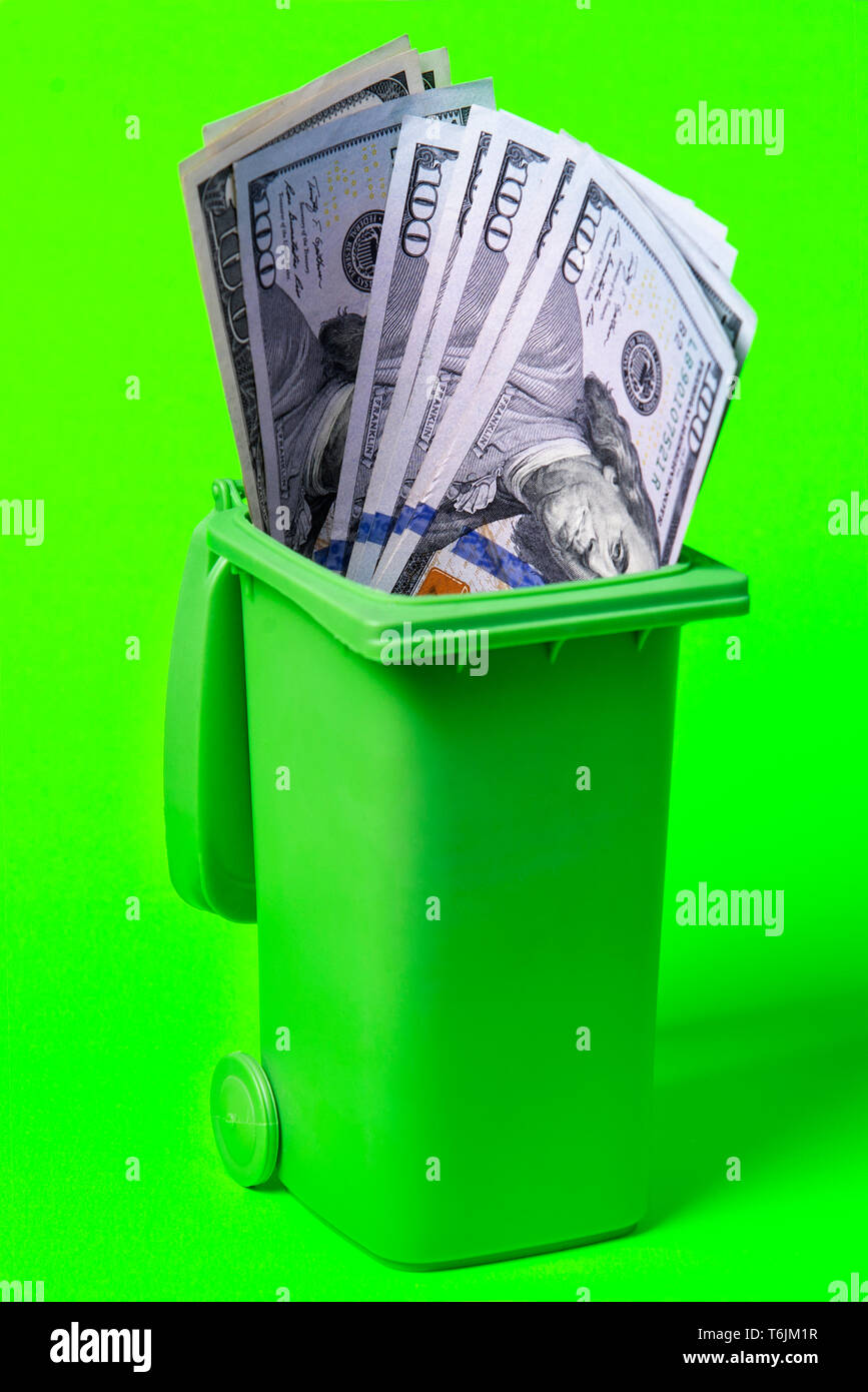 Money trash can isolated on green background Stock Photo - Alamy