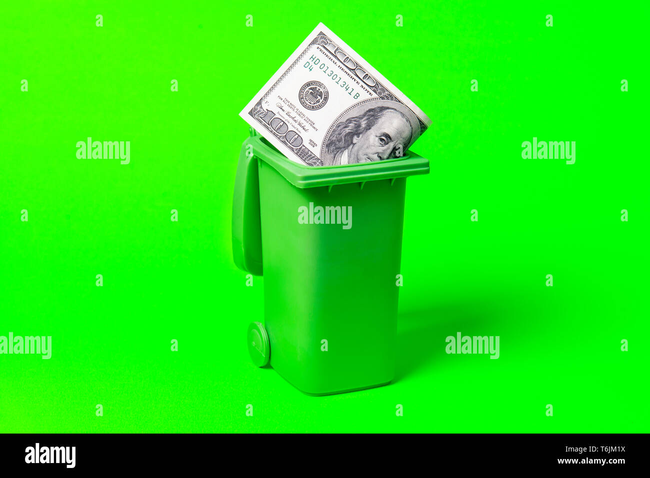 Money trash can isolated on green background Stock Photo - Alamy
