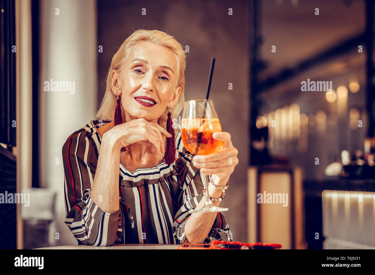 Pretty well-maintained old woman posing with glass of cocktail Stock ...