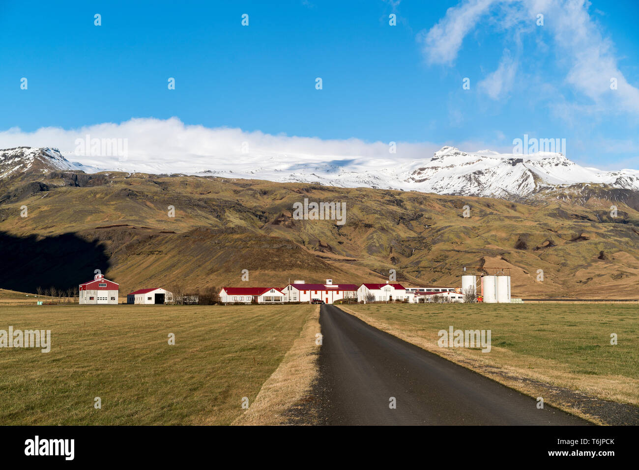View of a road leading to a farm at the foot of the snow-covered ...