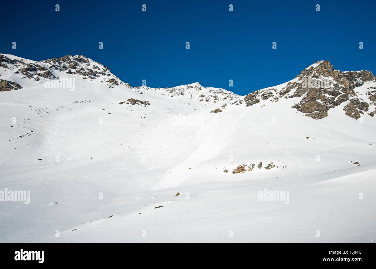 Panoramic view down snow covered valley in alpine mountain range on ...