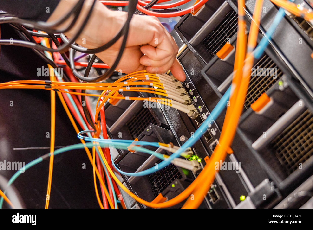 Male IT Engineer Plugging High Speed Fiber Cable In Network Switch ...