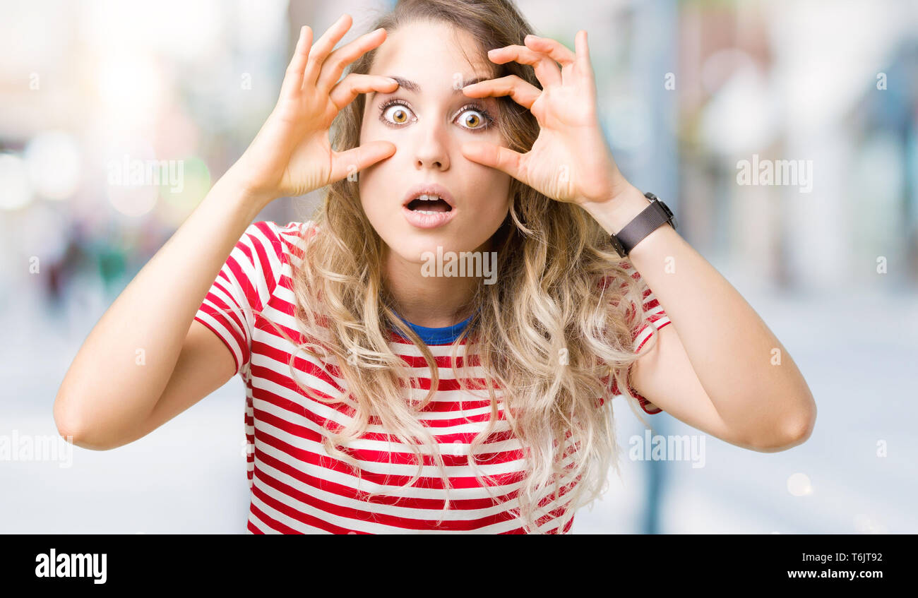 Beautiful young blonde woman over isolated background Trying to open ...