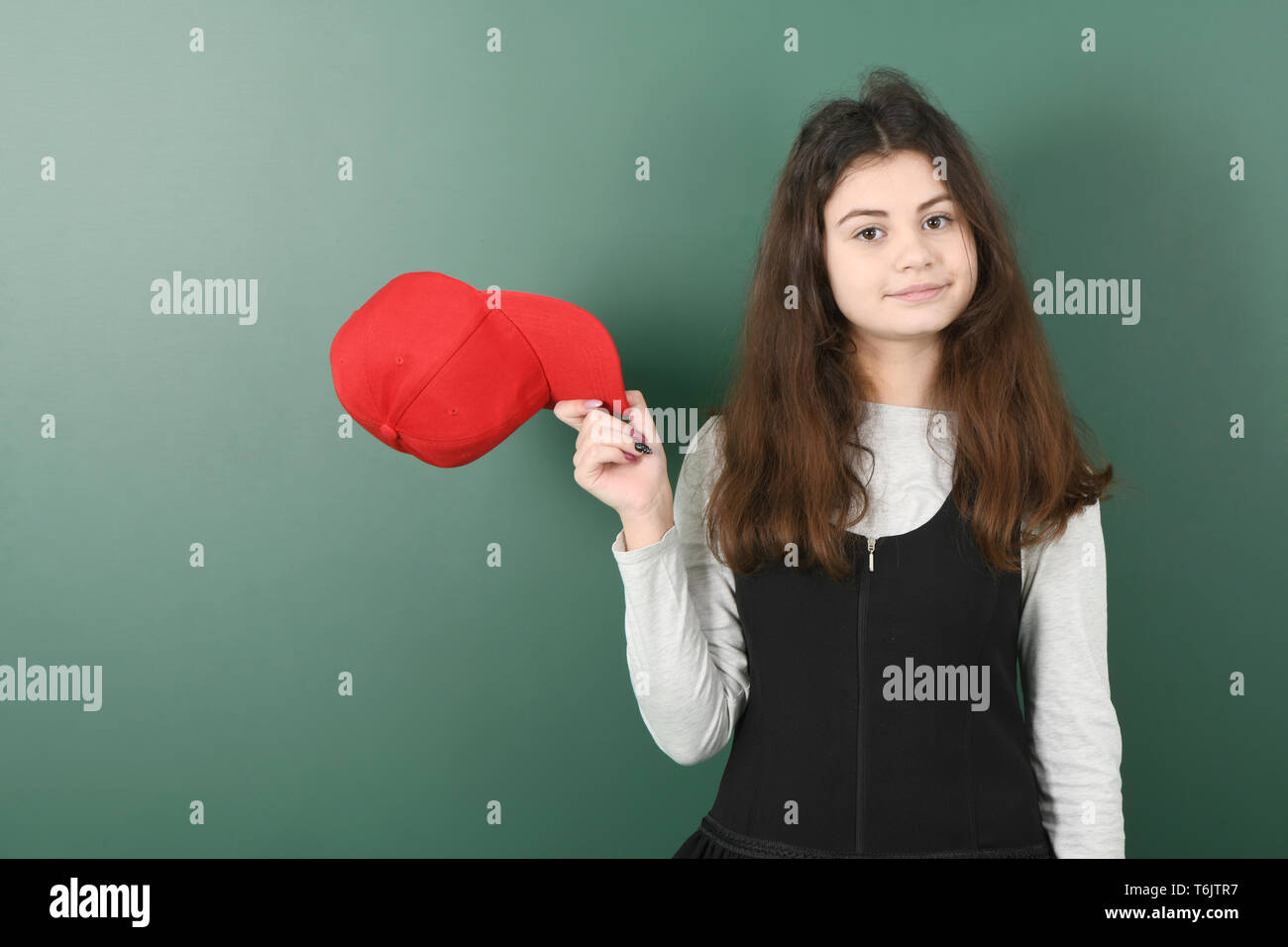 Smiling little schoolgirl on green background . Young playful girl ...