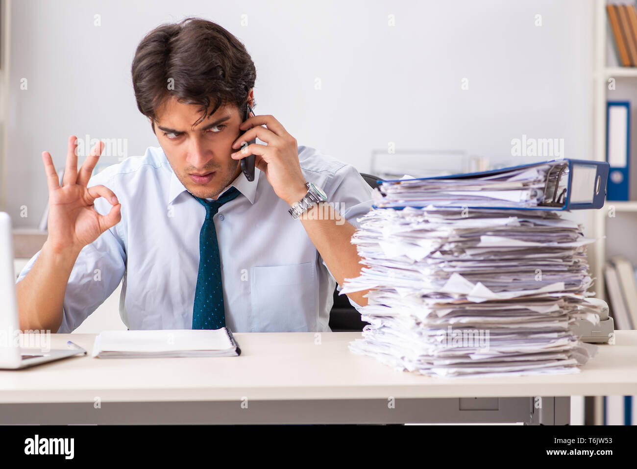 The overloaded busy employee with too much work and paperwork Stock ...