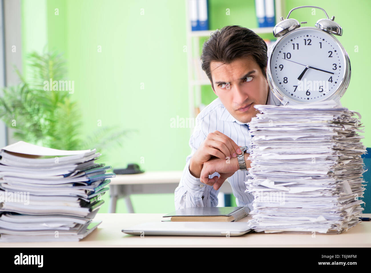 The businessman having problems with paperwork and workload Stock Photo ...