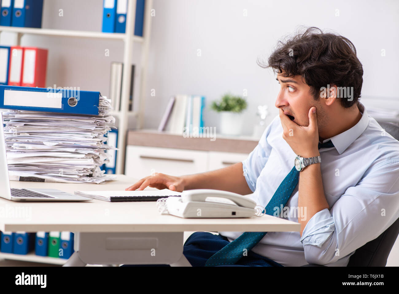 The overloaded busy employee with too much work and paperwork Stock ...