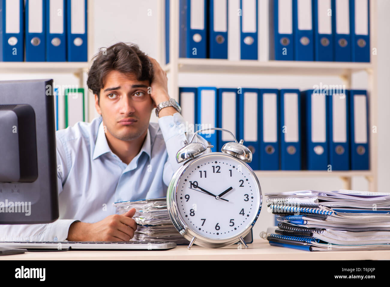 The overloaded busy employee with too much work and paperwork Stock ...