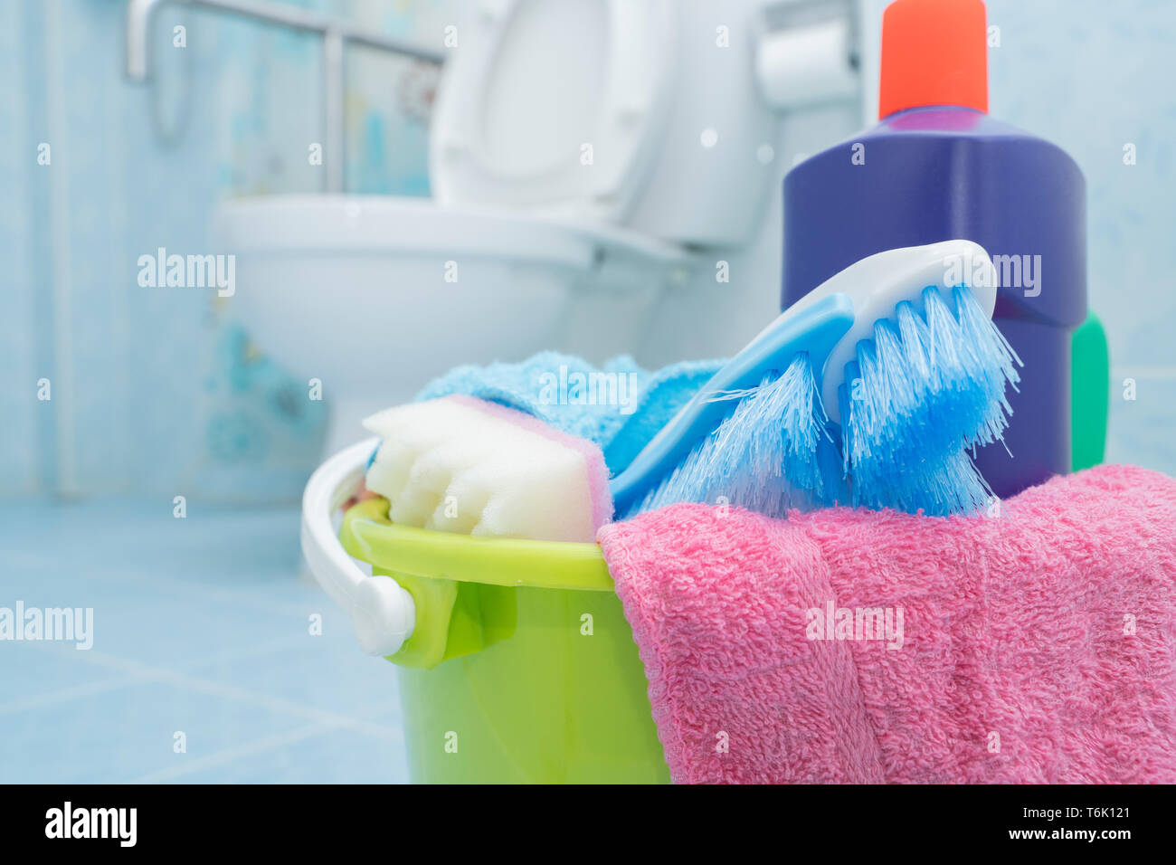 Cleaning with a bucket and cleaning products on blurred background ...