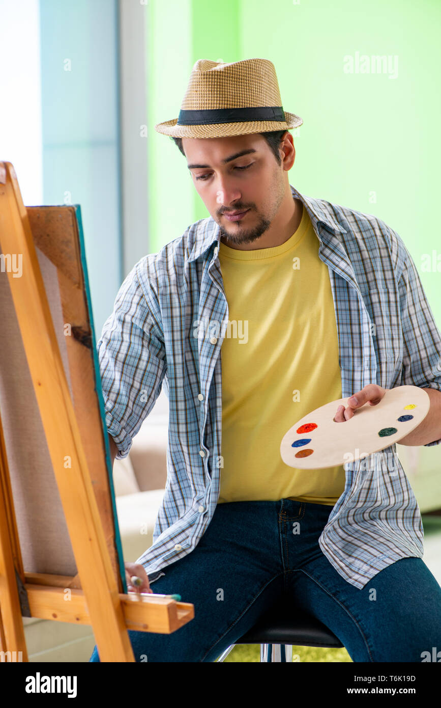 Young male artist working on new painting in his studio Stock Photo - Alamy