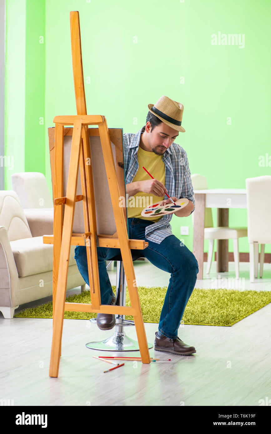 Young male artist working on new painting in his studio Stock Photo - Alamy