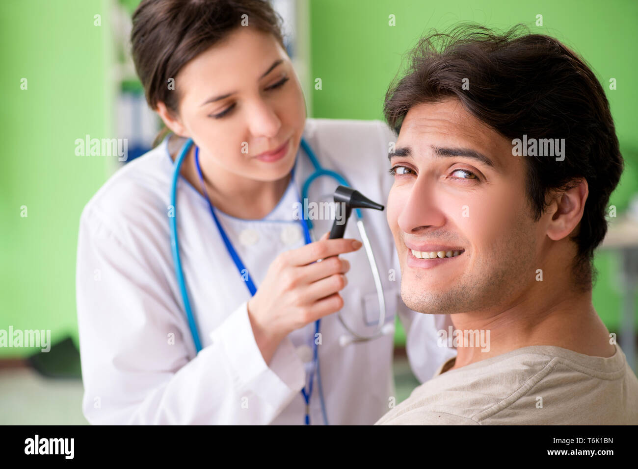 Female doctor checking patient's ear during medical examination Stock ...